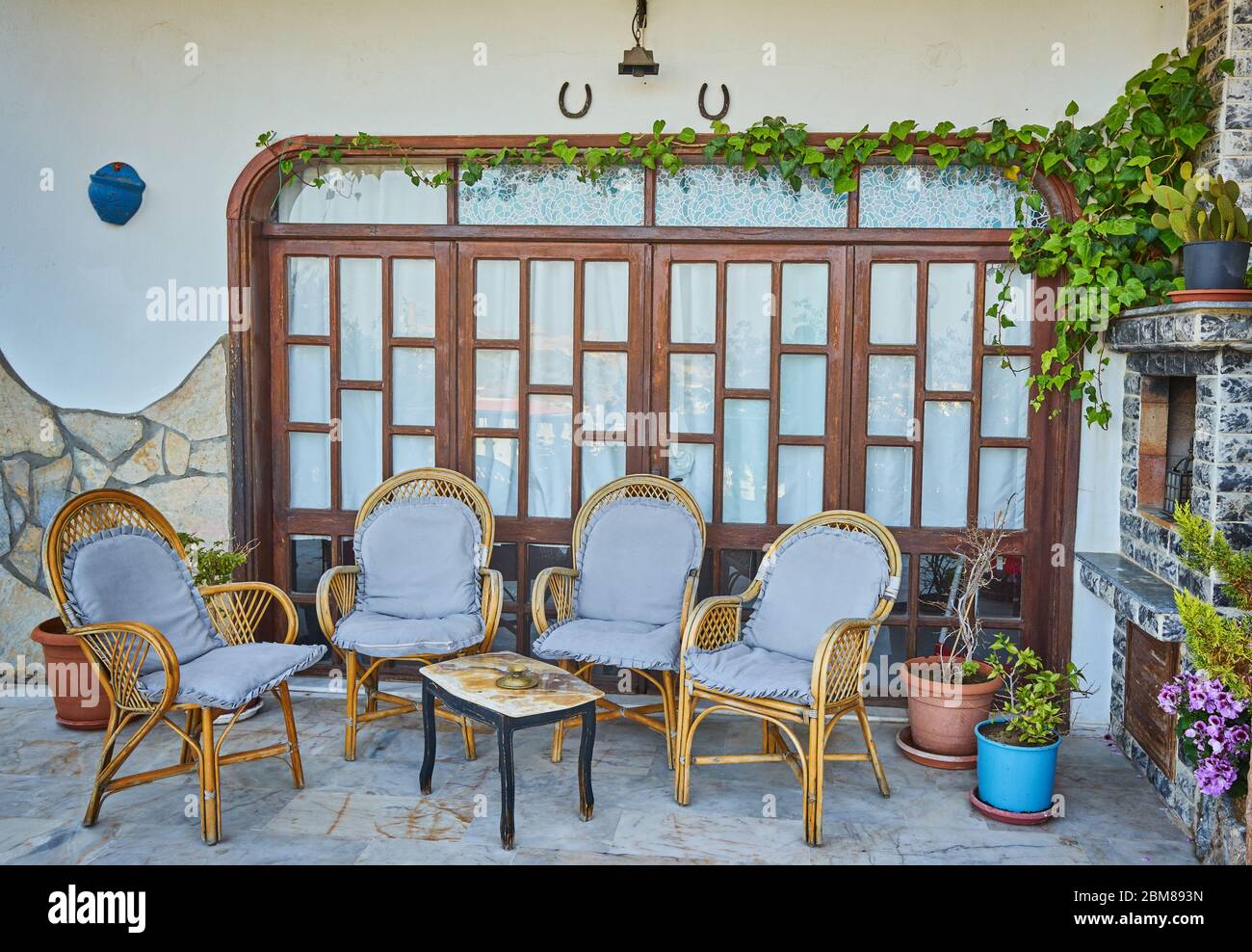 Classic view of a Greek blue window on a white wall with coffee table ...