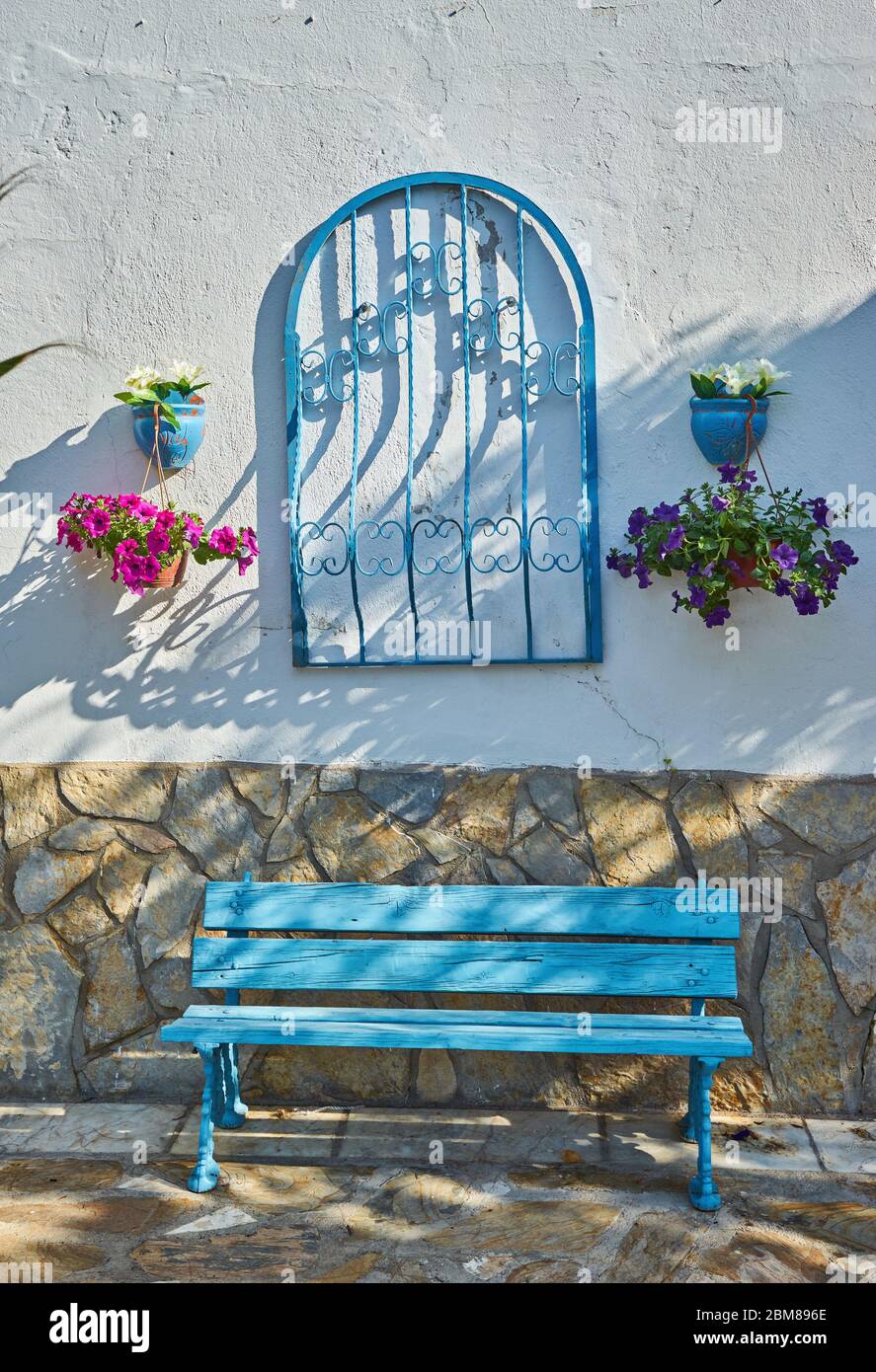 Classic view of a Greek blue window on a white wall with coffee table ...