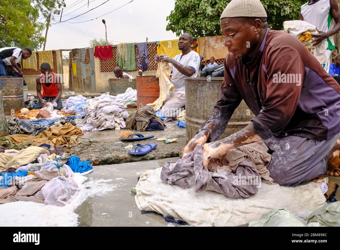 Man washing clothes by hand in a public laundry on the streets of Kano ...