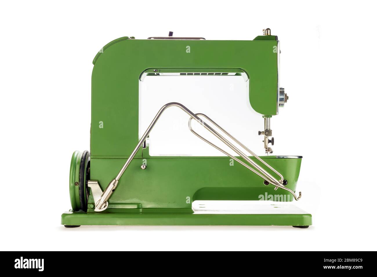 side view of an old vintage green sewing machine on white background ...