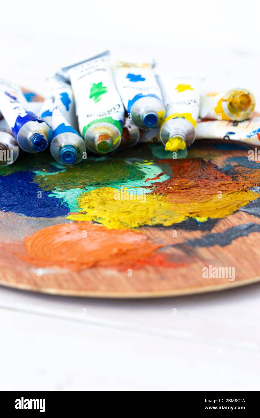 Artists oil paint tubes open and used on a wooden palette, with mixed ...