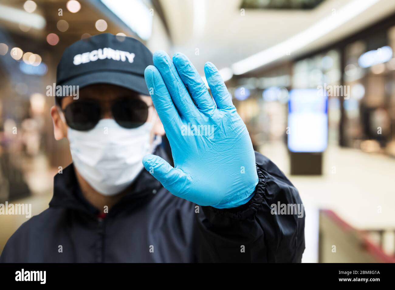 Security Guard Making Stop Hand Gesture In Shopping Mall Stock Photo ...