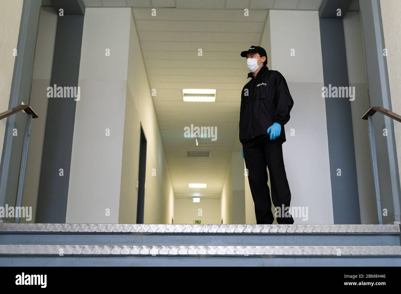 Security Guard In Face Mask At Entrance Stock Photo - Alamy
