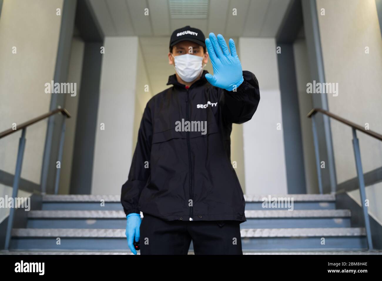 Security Guard In Face Mask Making Stop Gesture At Entrance Stock Photo ...
