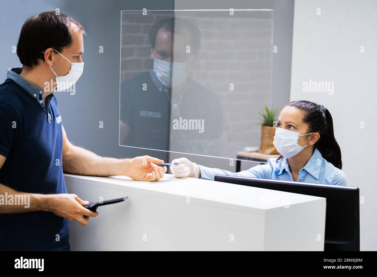 Client Handing Over Credit Card To A Cashier In Face Mask Stock Photo ...