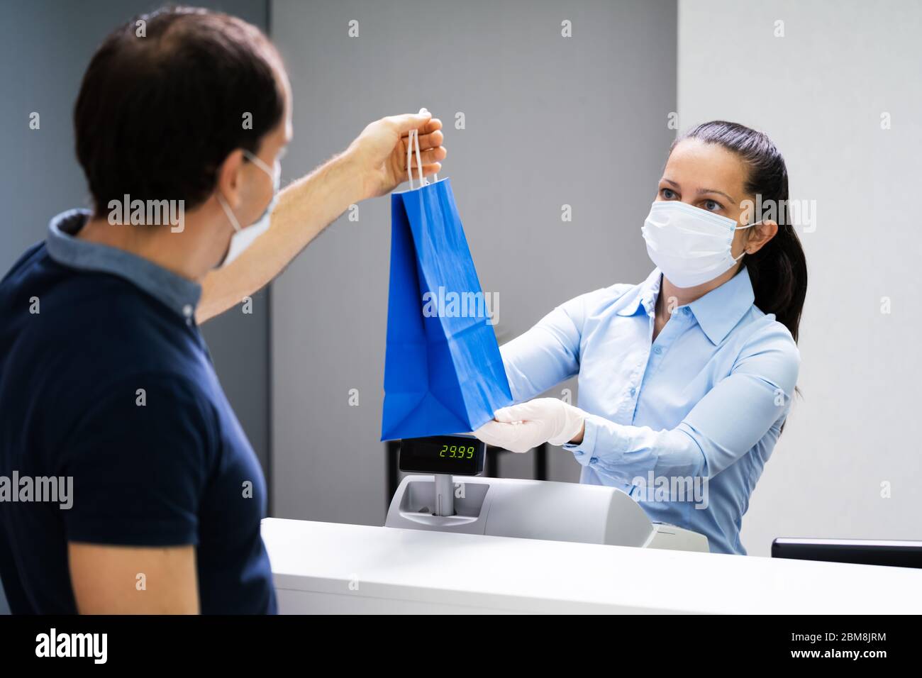 Cashier In Retail Shop Or Store At Counter Wearing Face Mask Stock ...
