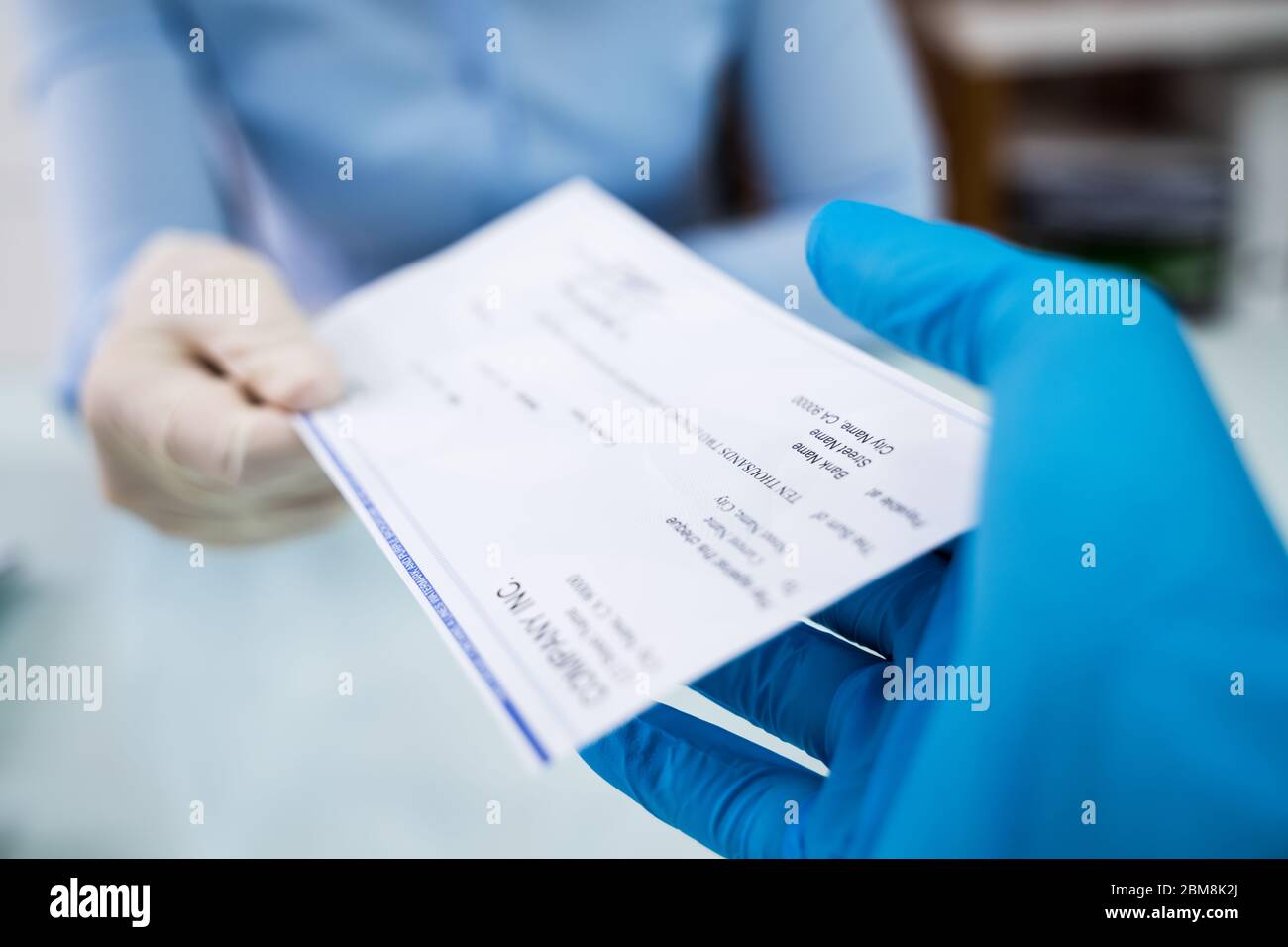 Giving Cheque Of Payroll Check To Employee In Gloves Stock Photo - Alamy
