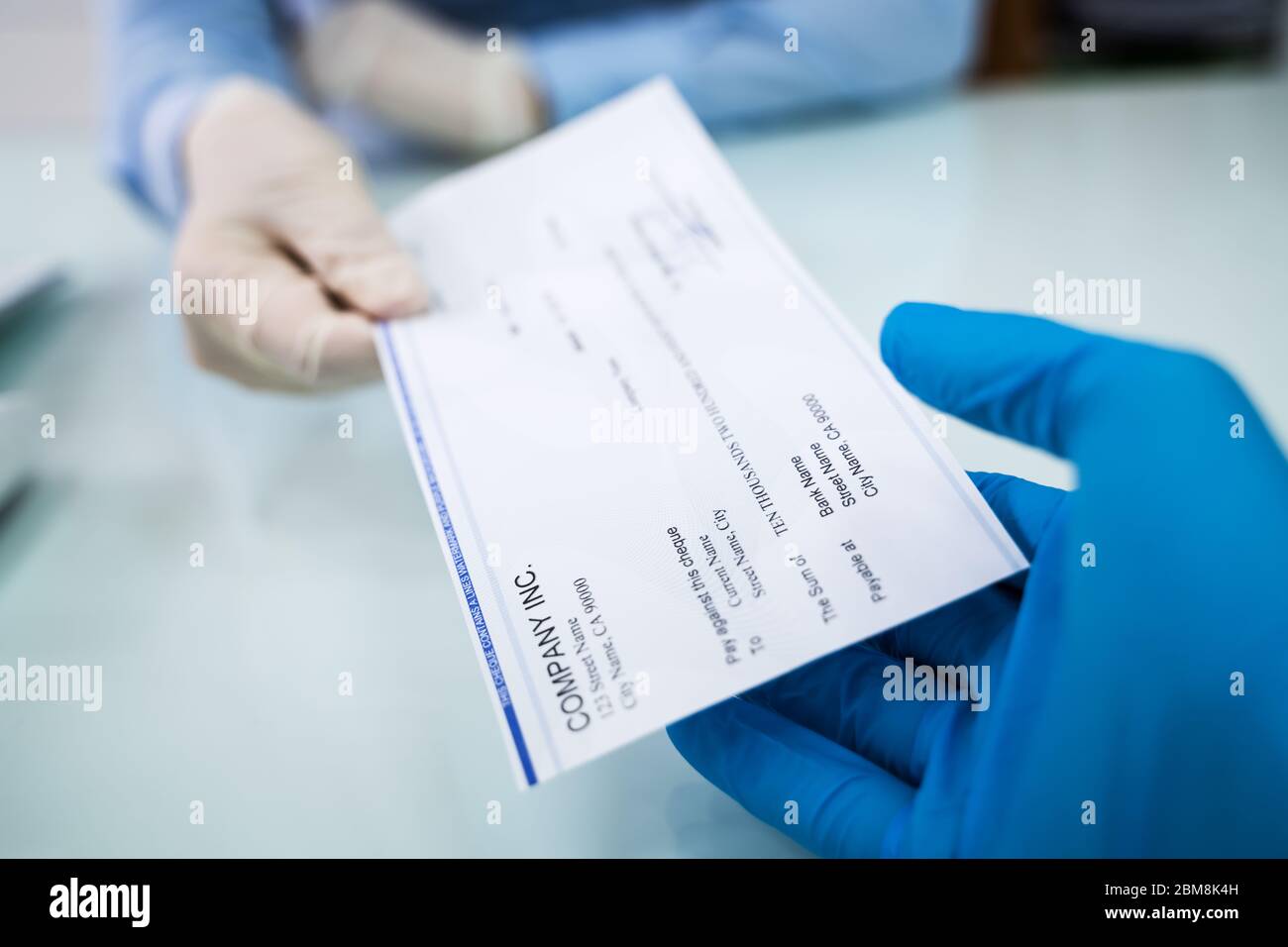 Giving Cheque Of Payroll Check To Employee In Gloves Stock Photo - Alamy
