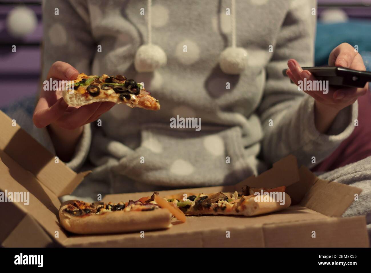 Woman watching tv eating pizza hi-res stock photography and images - Alamy