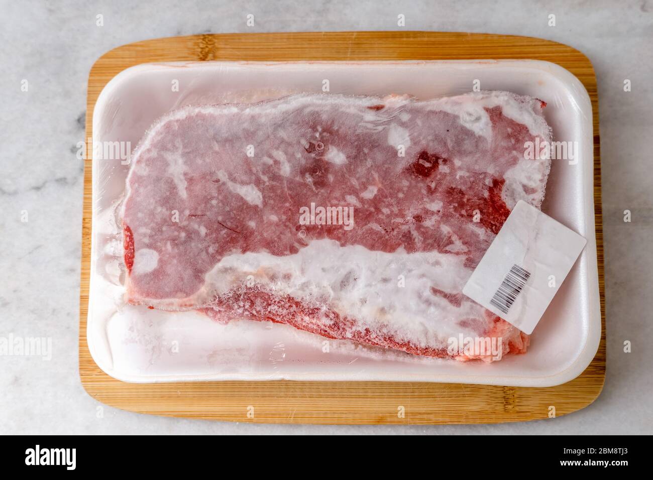 frozen beef wrapped with stretch film on cutting board Stock Photo - Alamy
