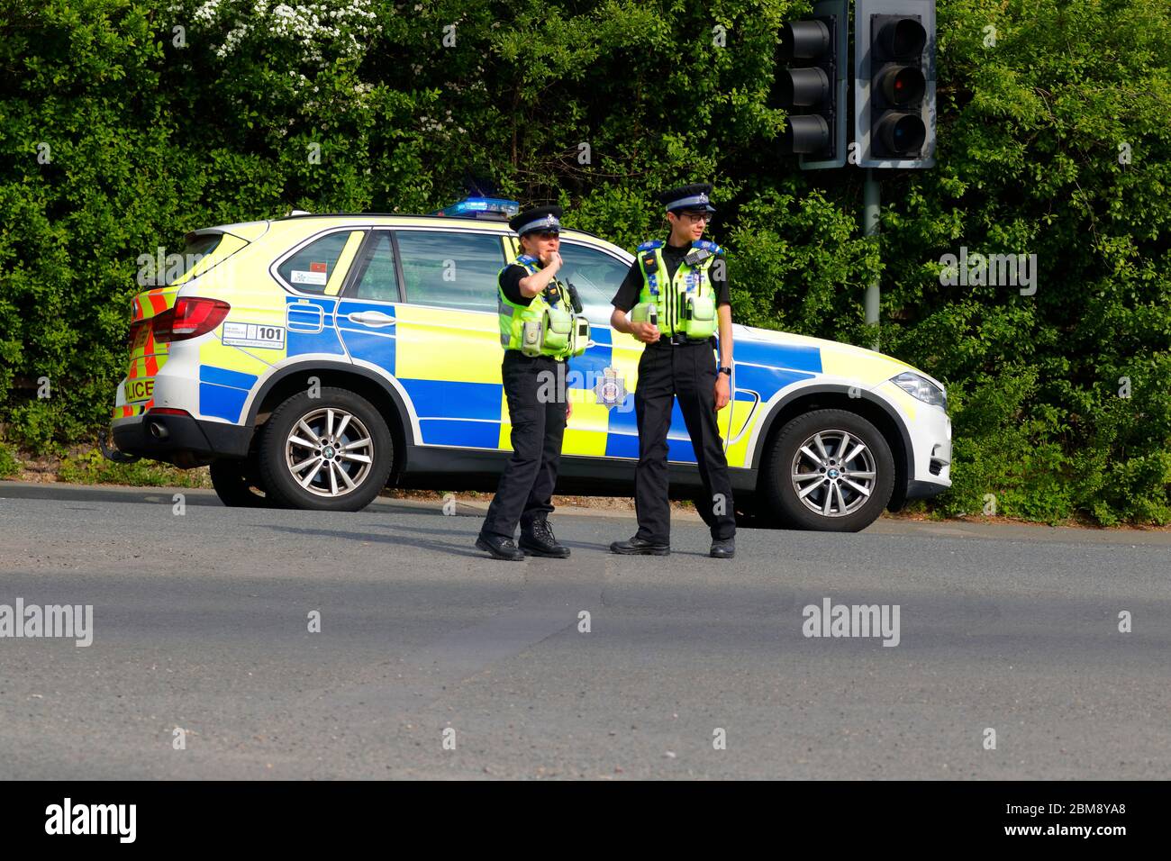 Police officers stand at a road block, to redirect traffic away from a ...