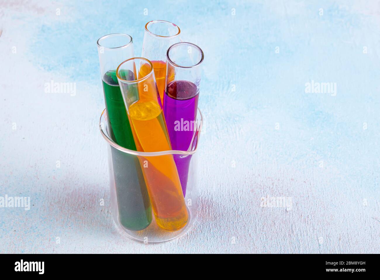 Test tubes in a rack containing rainbow colored solutions. Laboratory ...