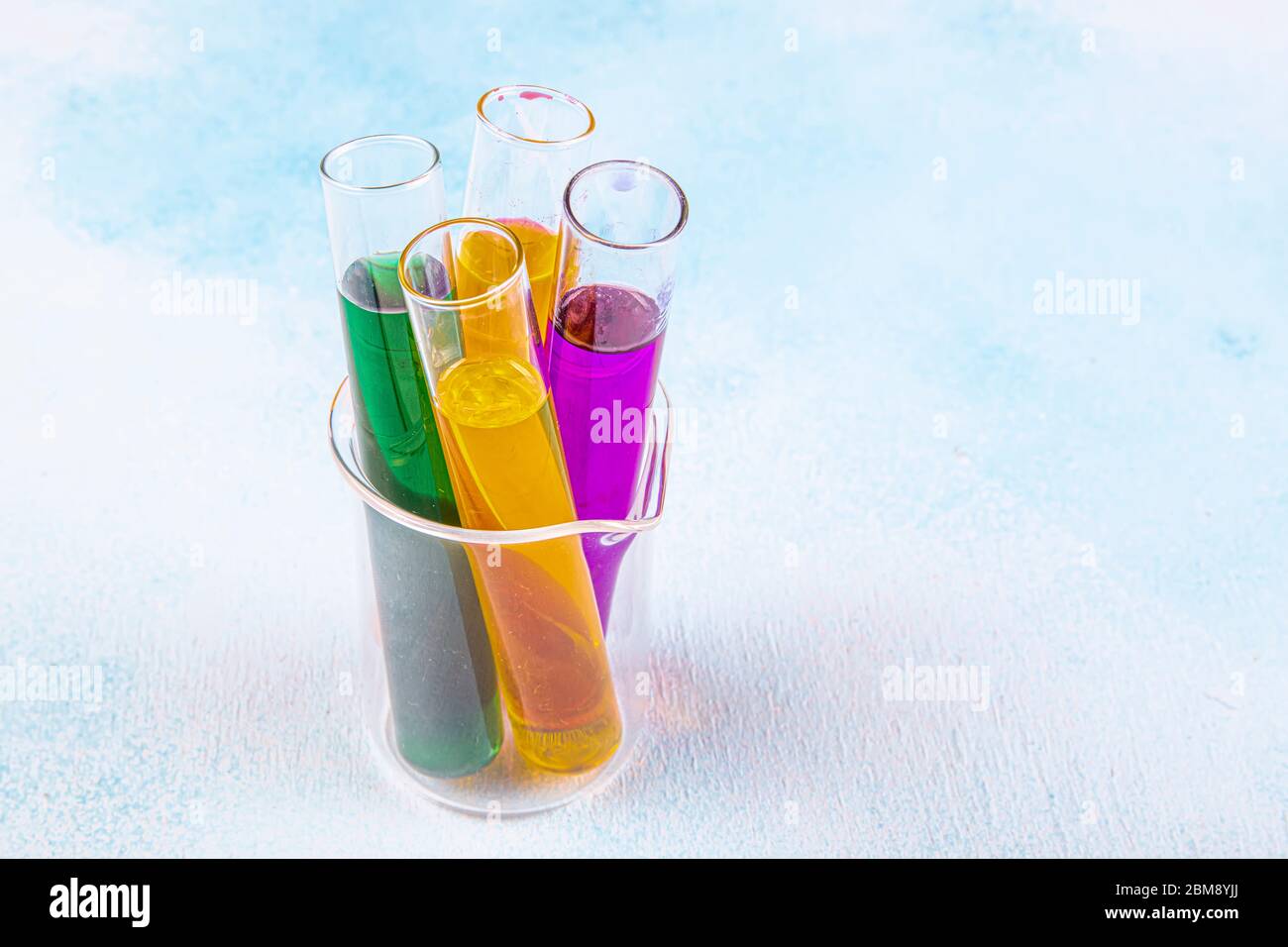 Test tubes in a rack containing rainbow colored solutions. Laboratory ...