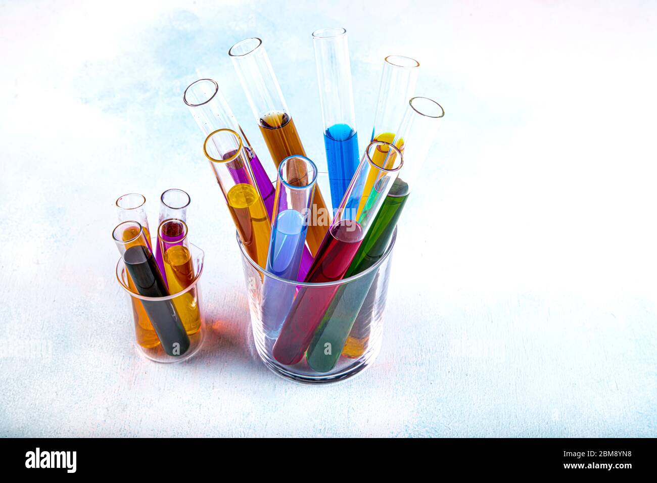 Test tubes in a rack containing rainbow colored solutions. Laboratory ...
