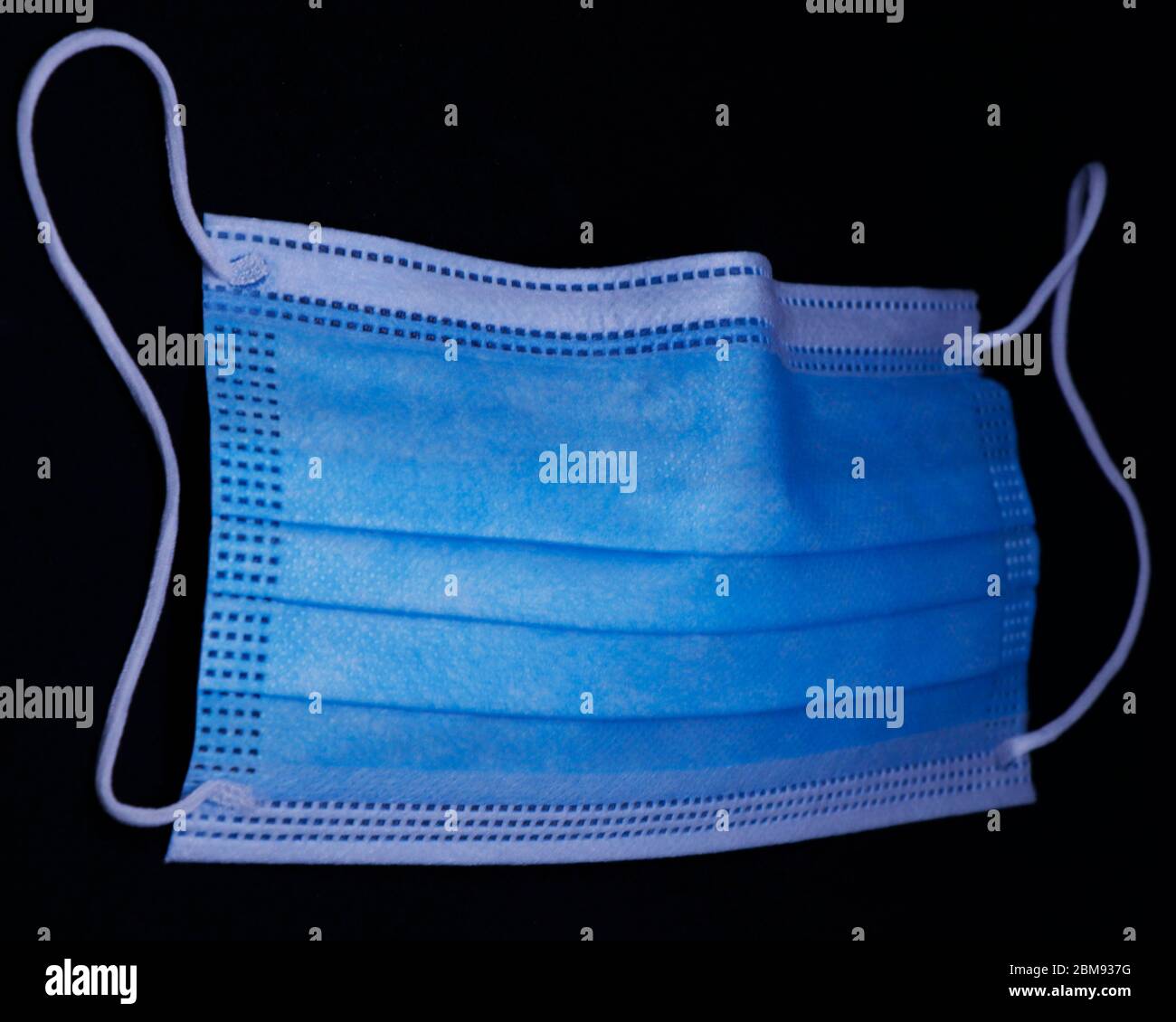 medical blue face mask isolated with black background Stock Photo - Alamy
