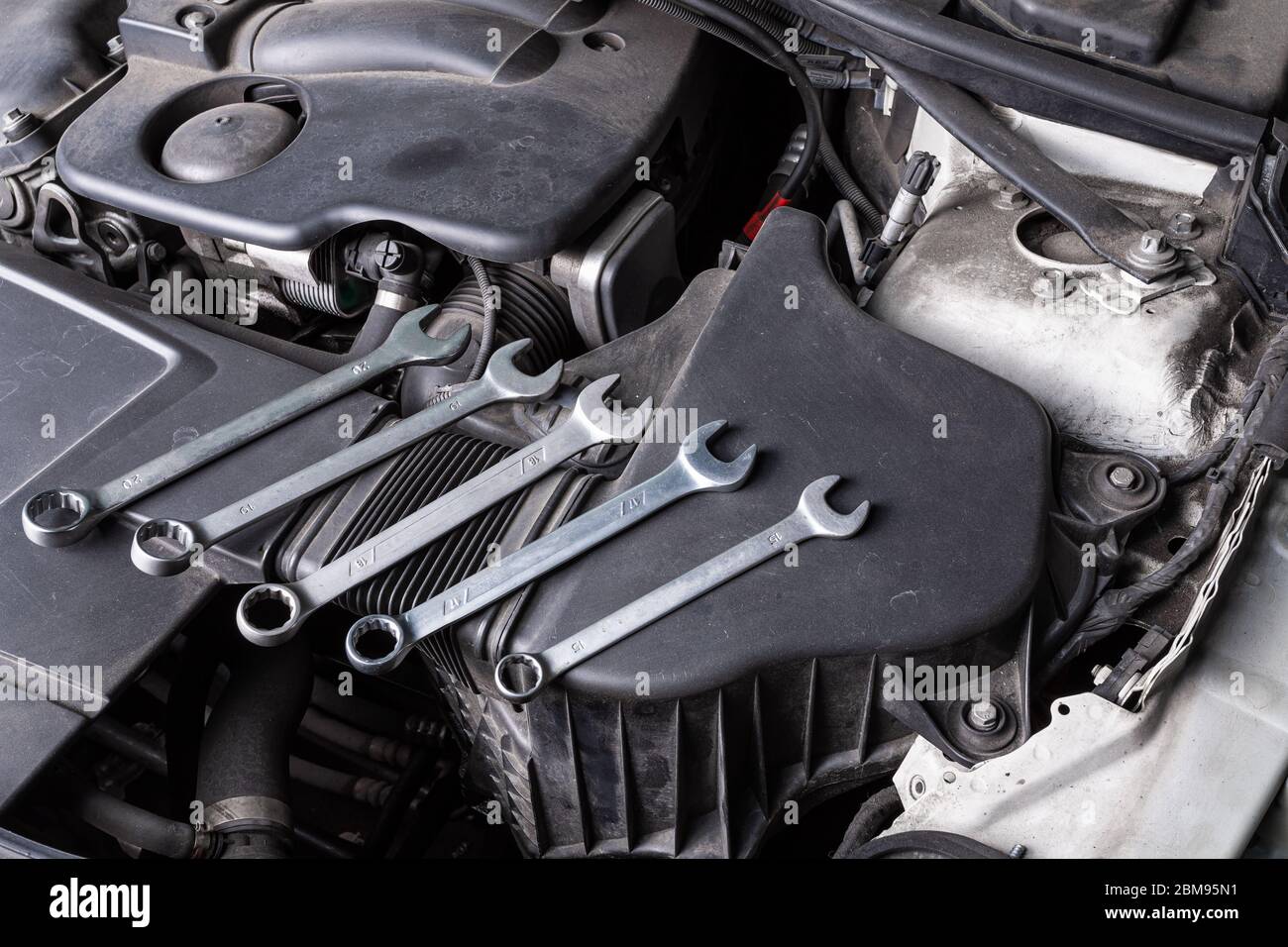 A set of metal spanners of different sizes lies under the hood of the ...