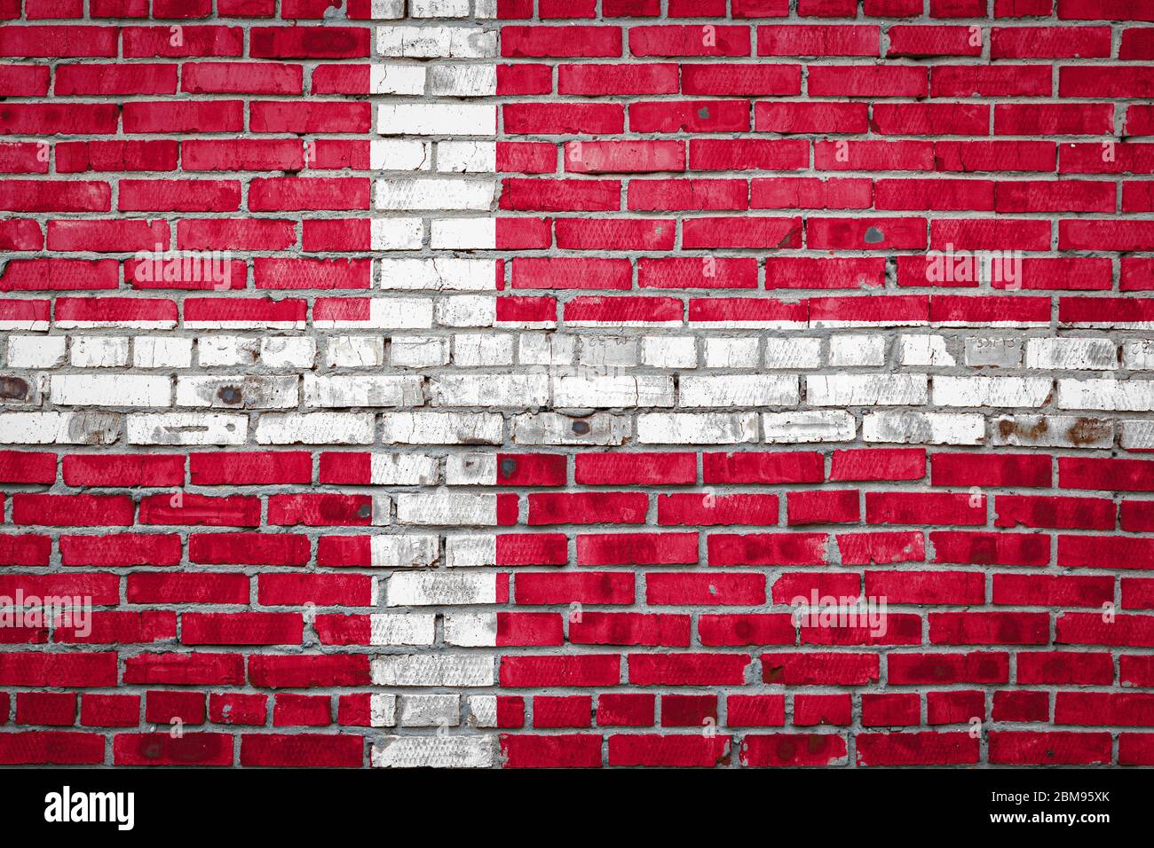 National flag of Denmark depicting in paint colors on an old brick wall ...