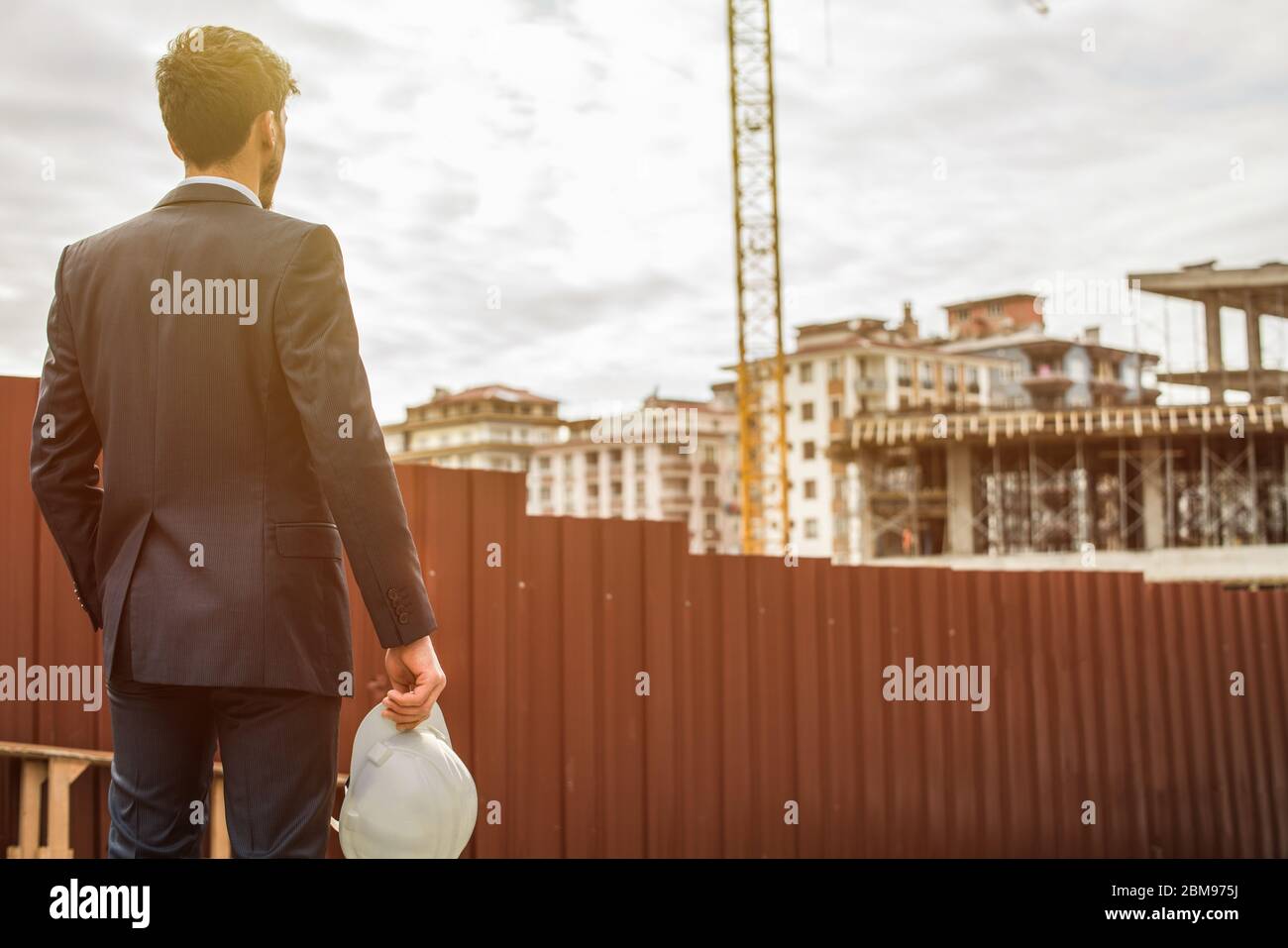 Young male civil engineer or businessman makes shadow by lifting his ...