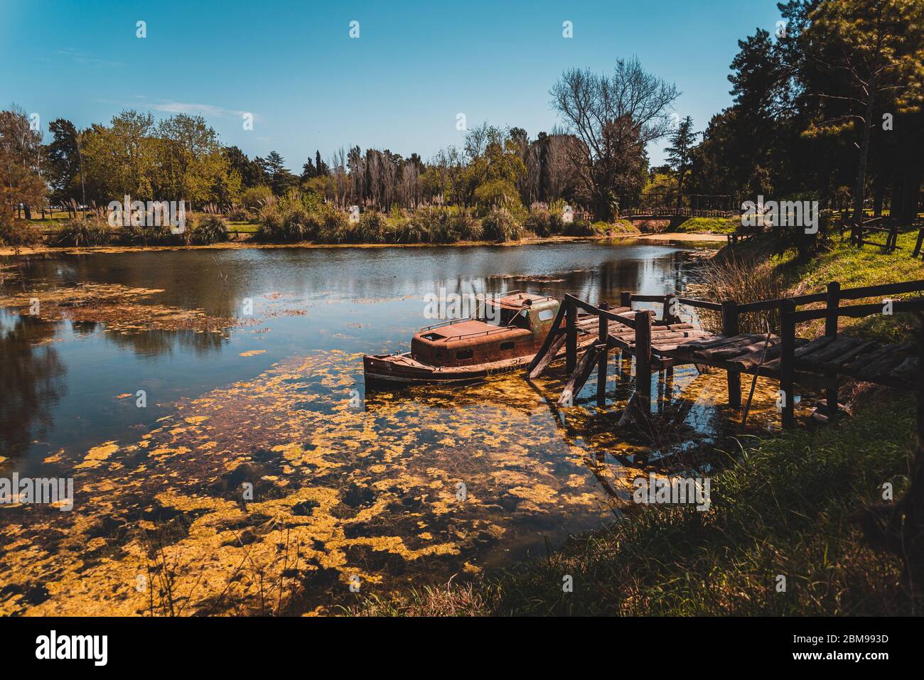 Old rusty abandoned wrecked ship tied up to a broken wooden dock in a ...