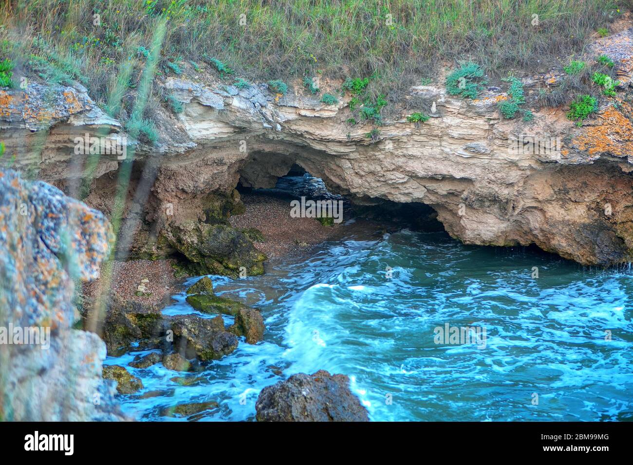 natural tunnel through the coastal cliff Stock Photo - Alamy