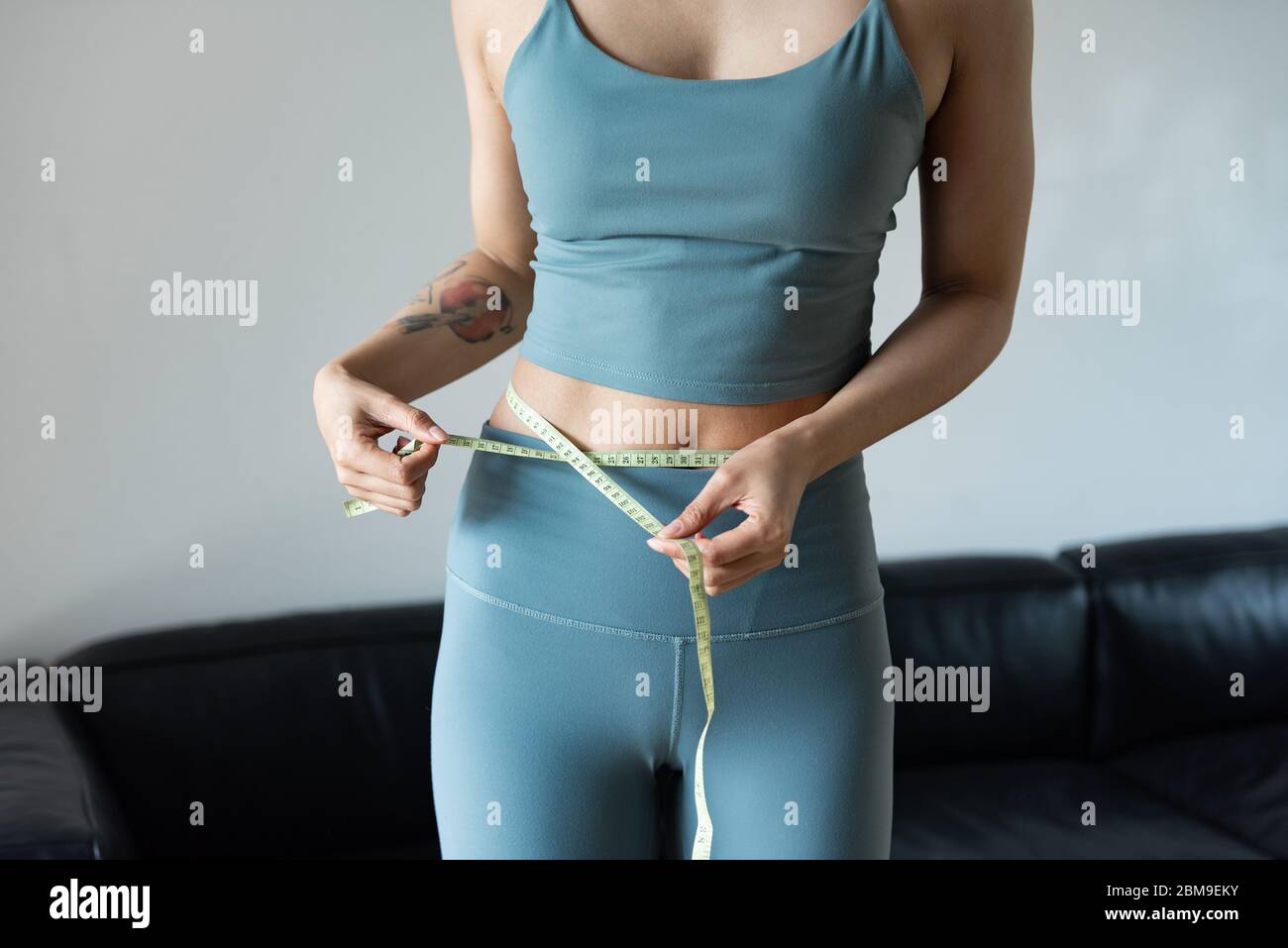 A young Asian woman measures the waist with a ruler Stock Photo - Alamy