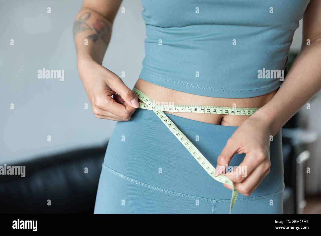 A young Asian woman measures the waist with a ruler Stock Photo - Alamy