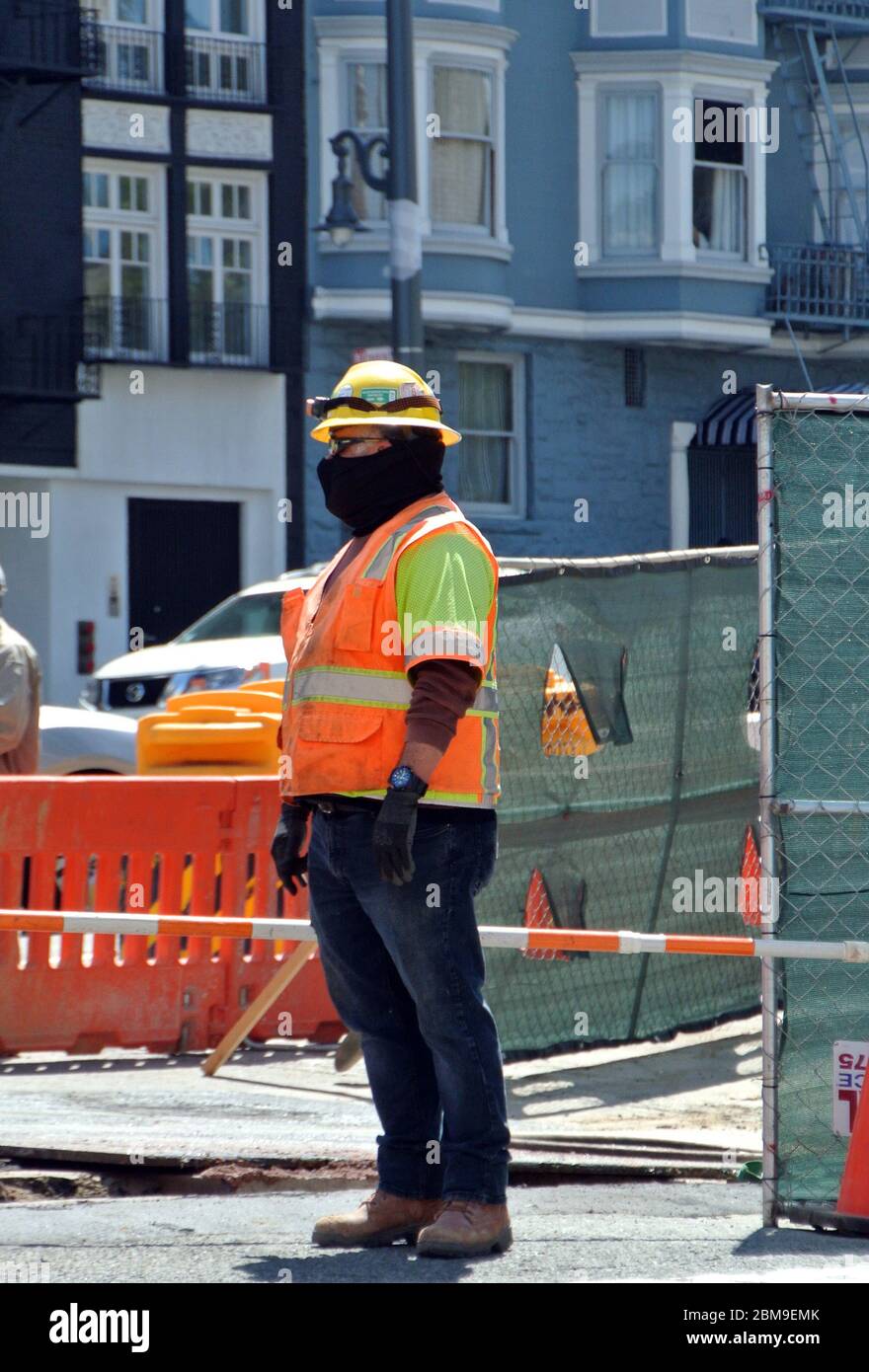 workers in construction zone practice social distancing wearing mask ...