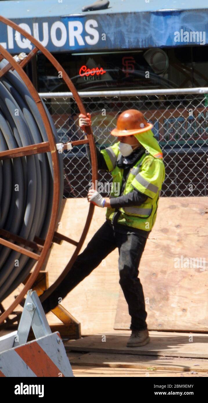 workers in construction zone practice social distancing wearing mask ...