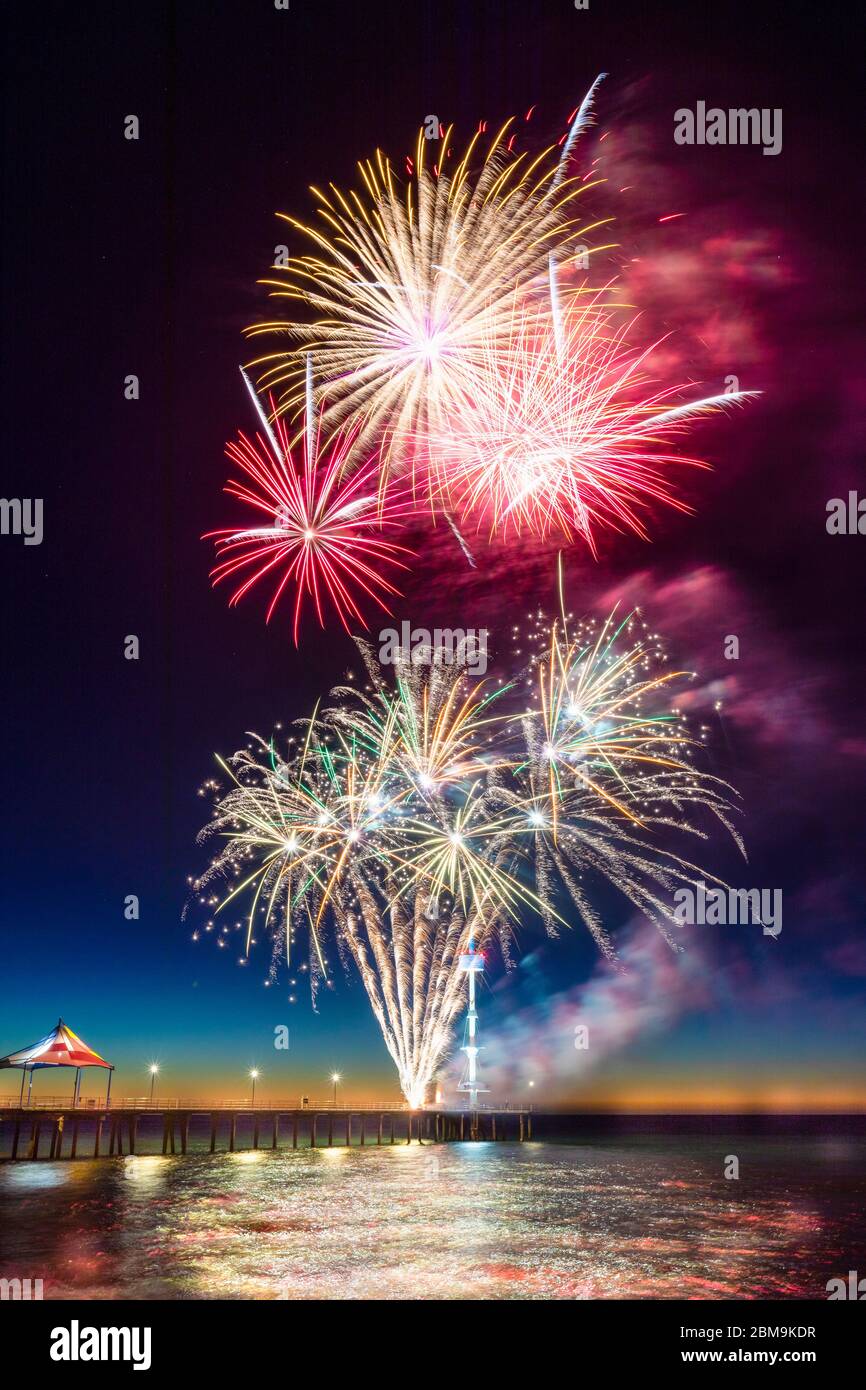 Colourful New Years Fireworks Display lighting up the sky and water off ...
