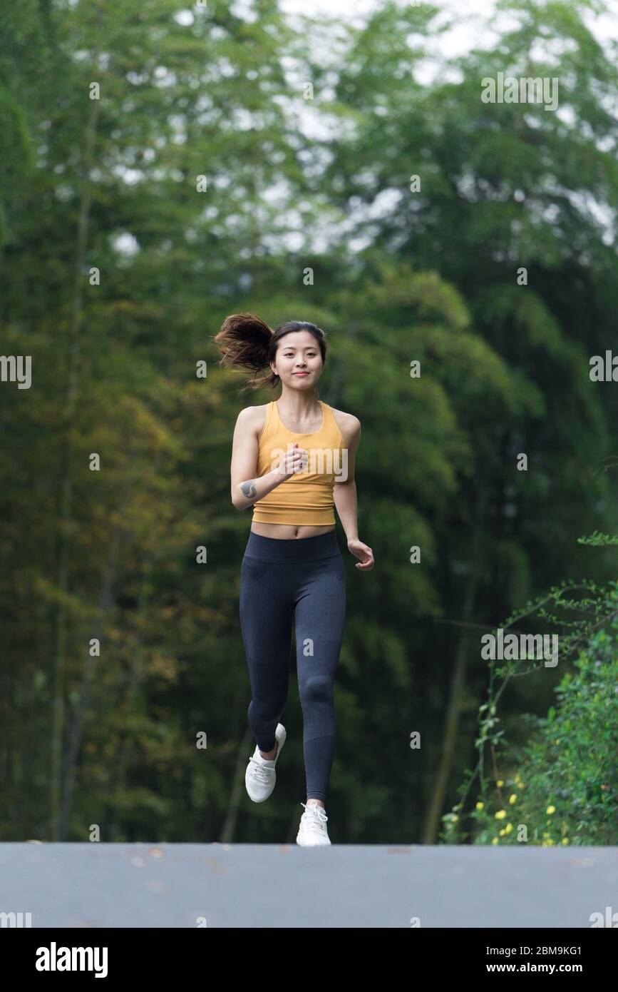 A young Asian woman is running Stock Photo - Alamy