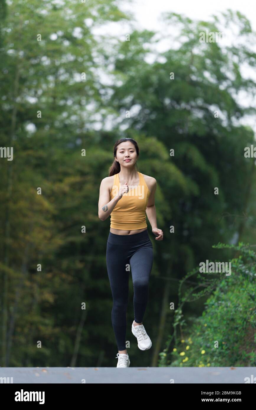 A young Asian woman is running Stock Photo - Alamy