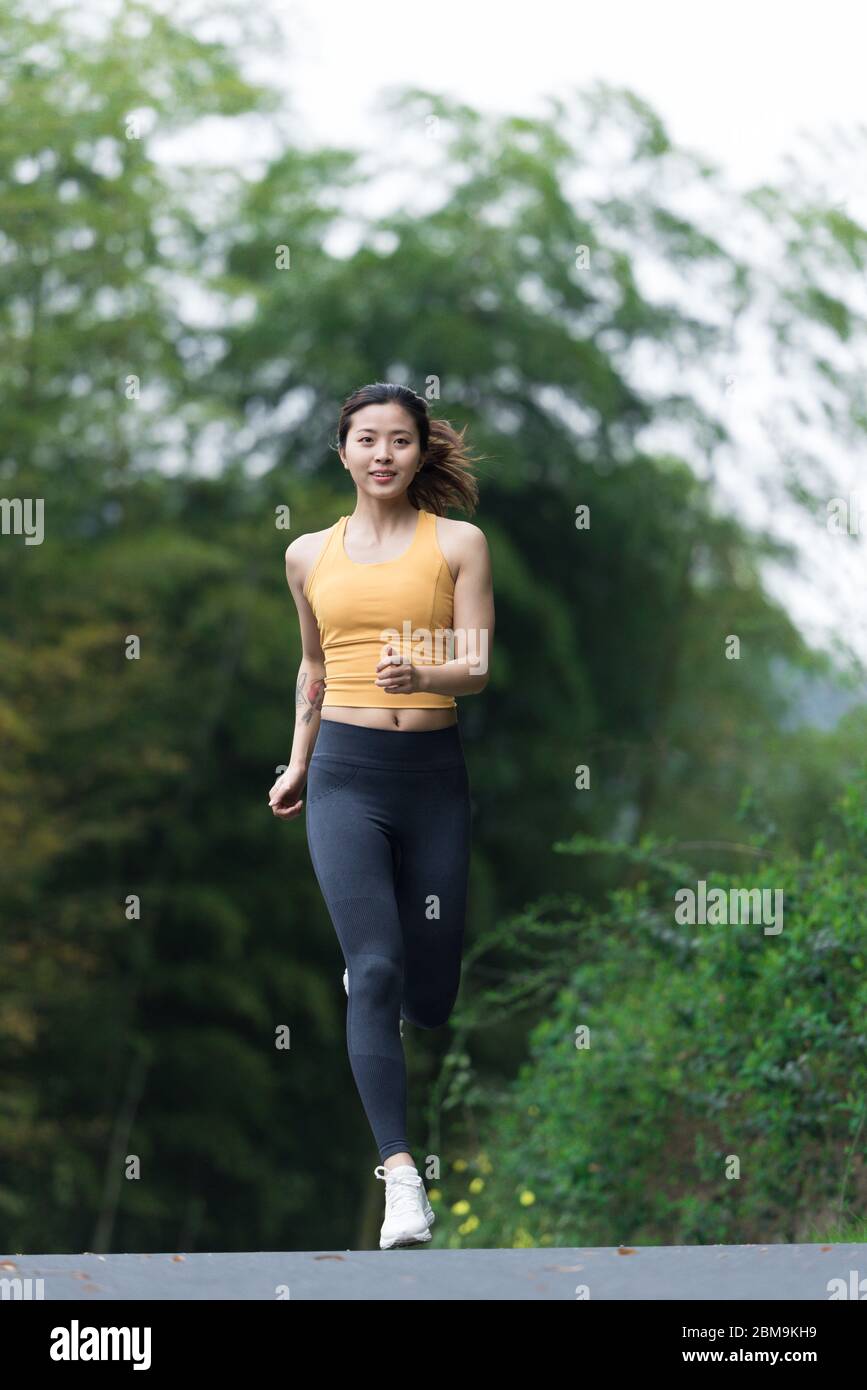 A young Asian woman is running Stock Photo - Alamy