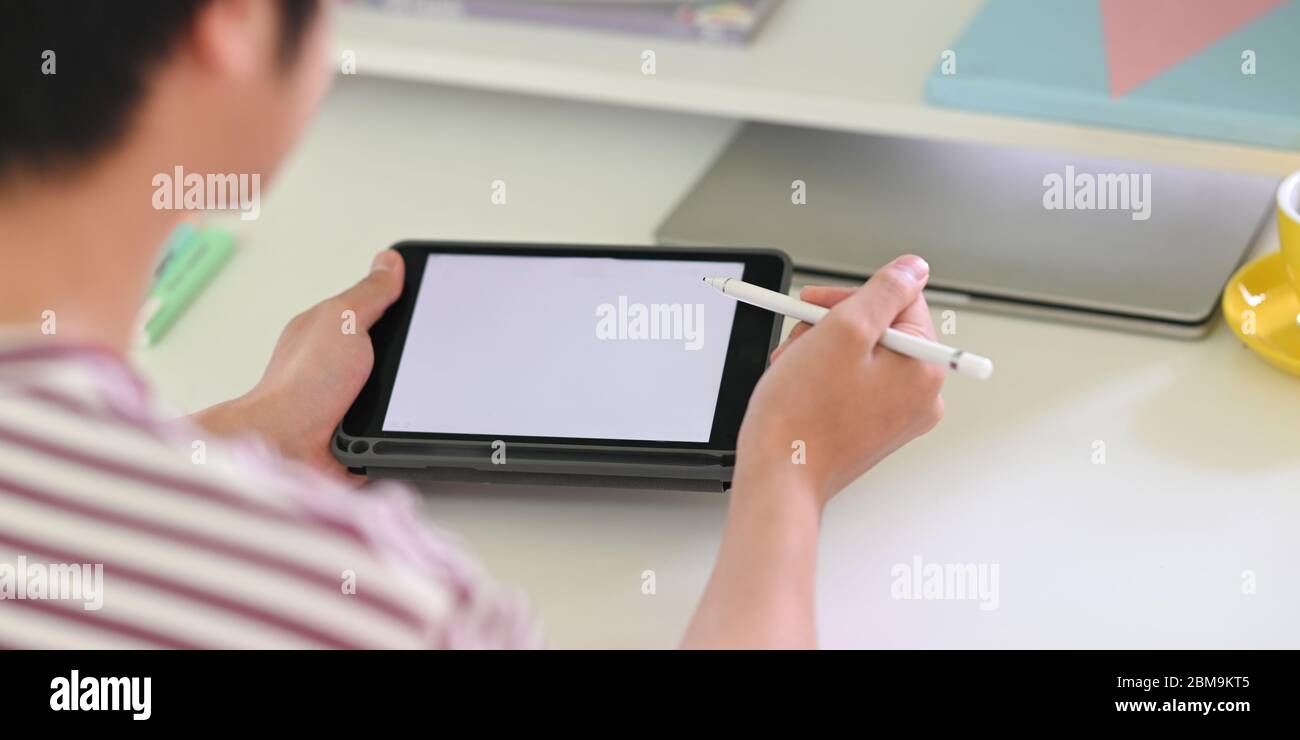 Behind shot of young creative man drawing on white blank screen ...