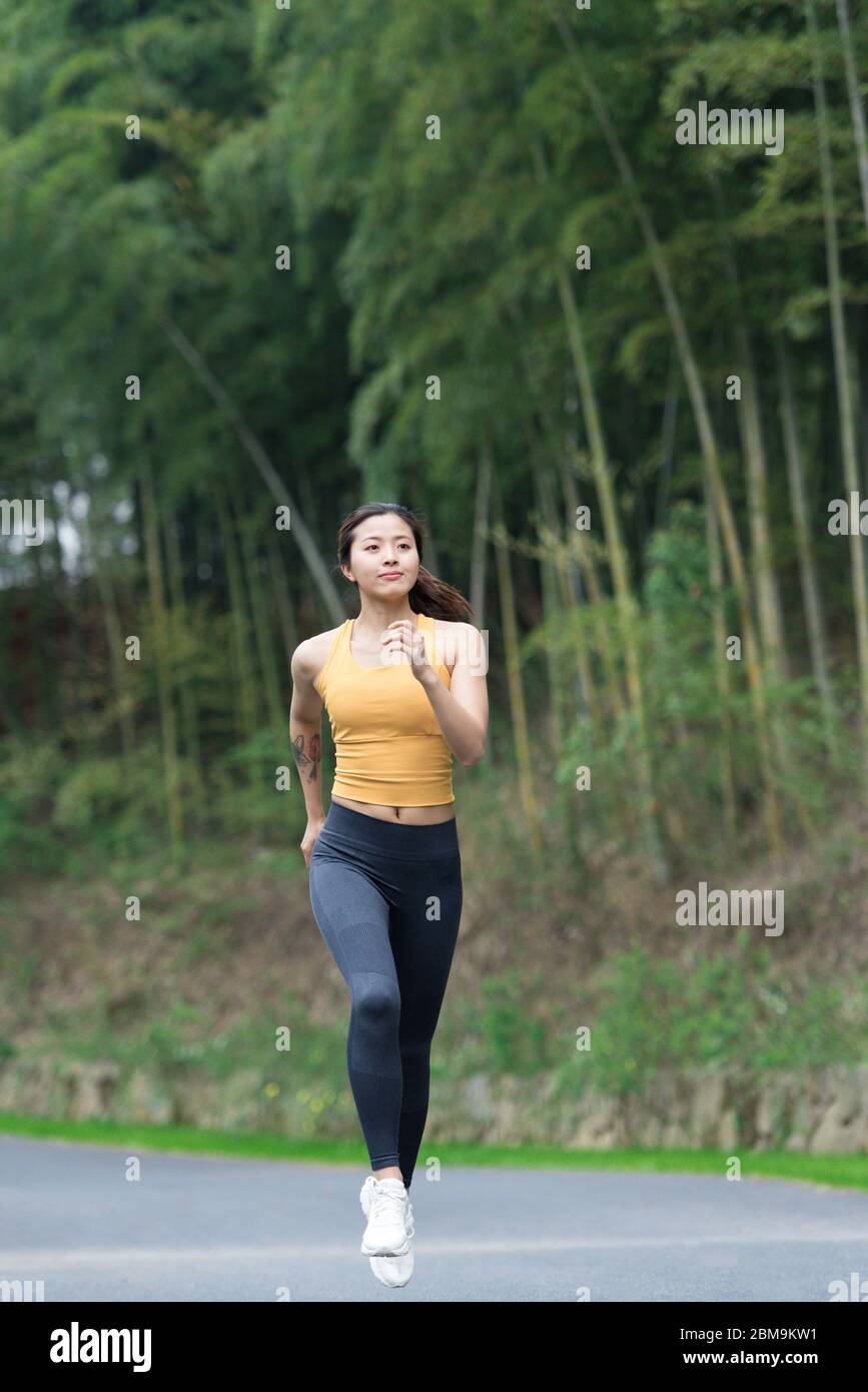 A young Asian woman is running Stock Photo - Alamy