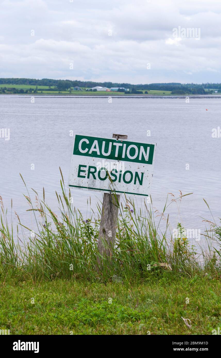 Caution Erosion warning sign. Notice posted on North Rustico Harbour’s ...