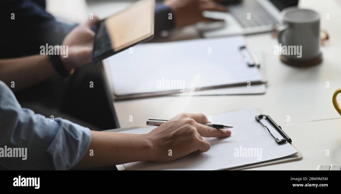 Cropped image of business developer team working together with computer ...