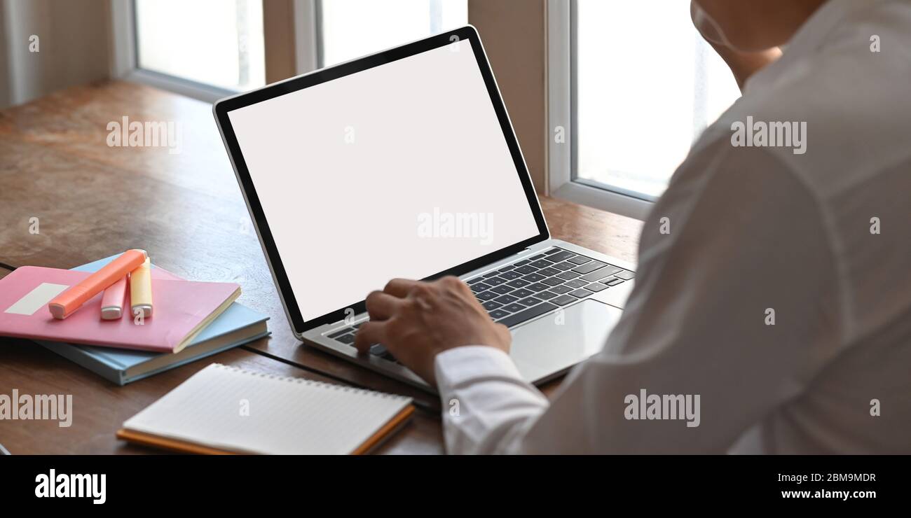 Closeup image of smart man typing on computer laptop with white blank ...