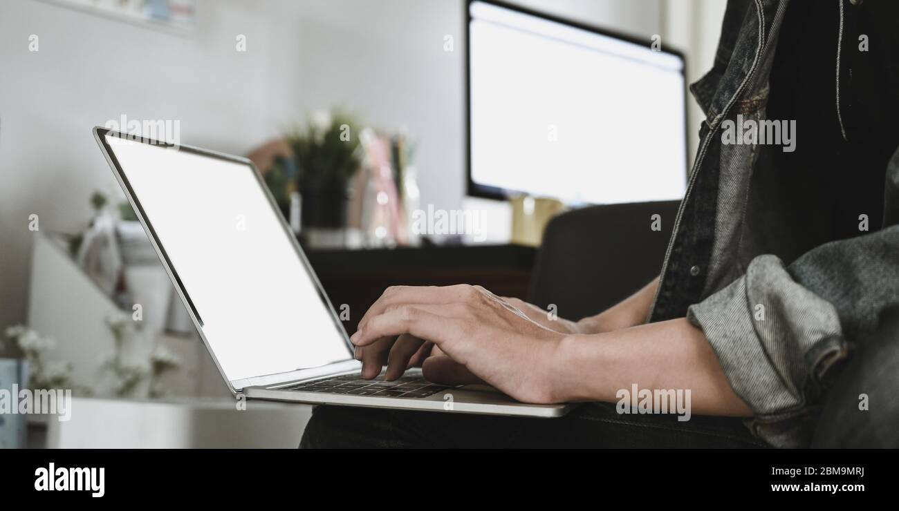 Cropped image of smart man's hands typing on white blank screen ...