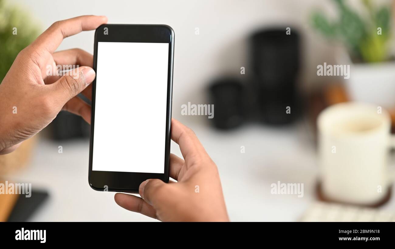 Cropped image of smart man's hands holding a cropped black smartphone ...