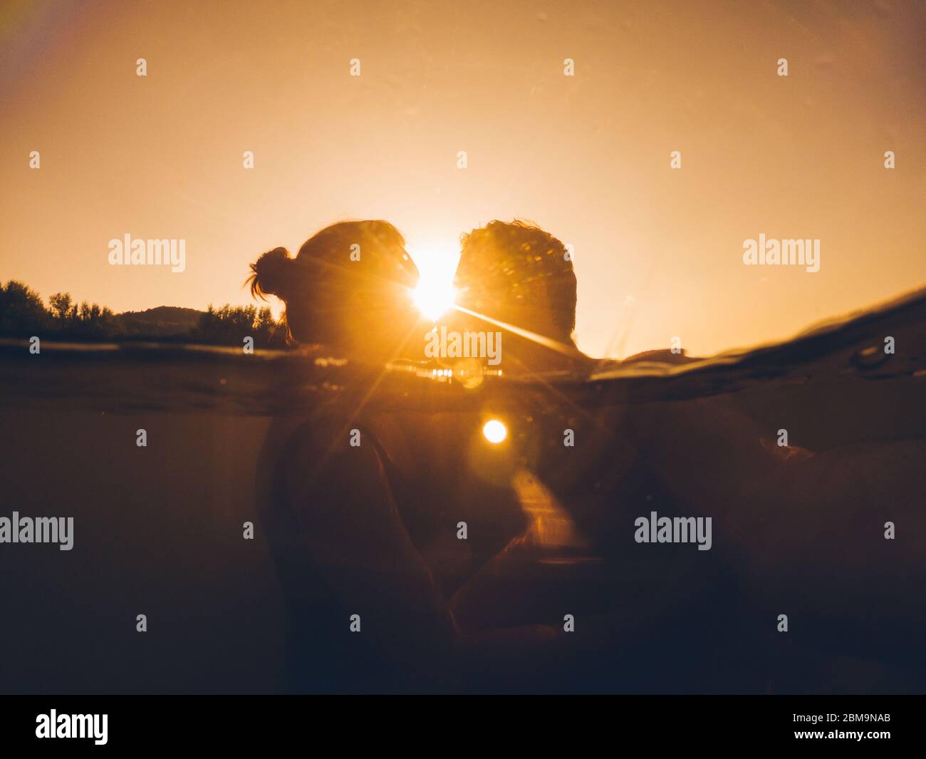 couple kissing in water with back light Stock Photo - Alamy