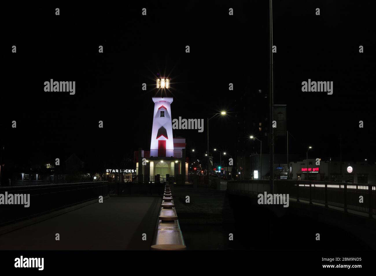 Night time. Old working lighthouse and bridge Stock Photo - Alamy