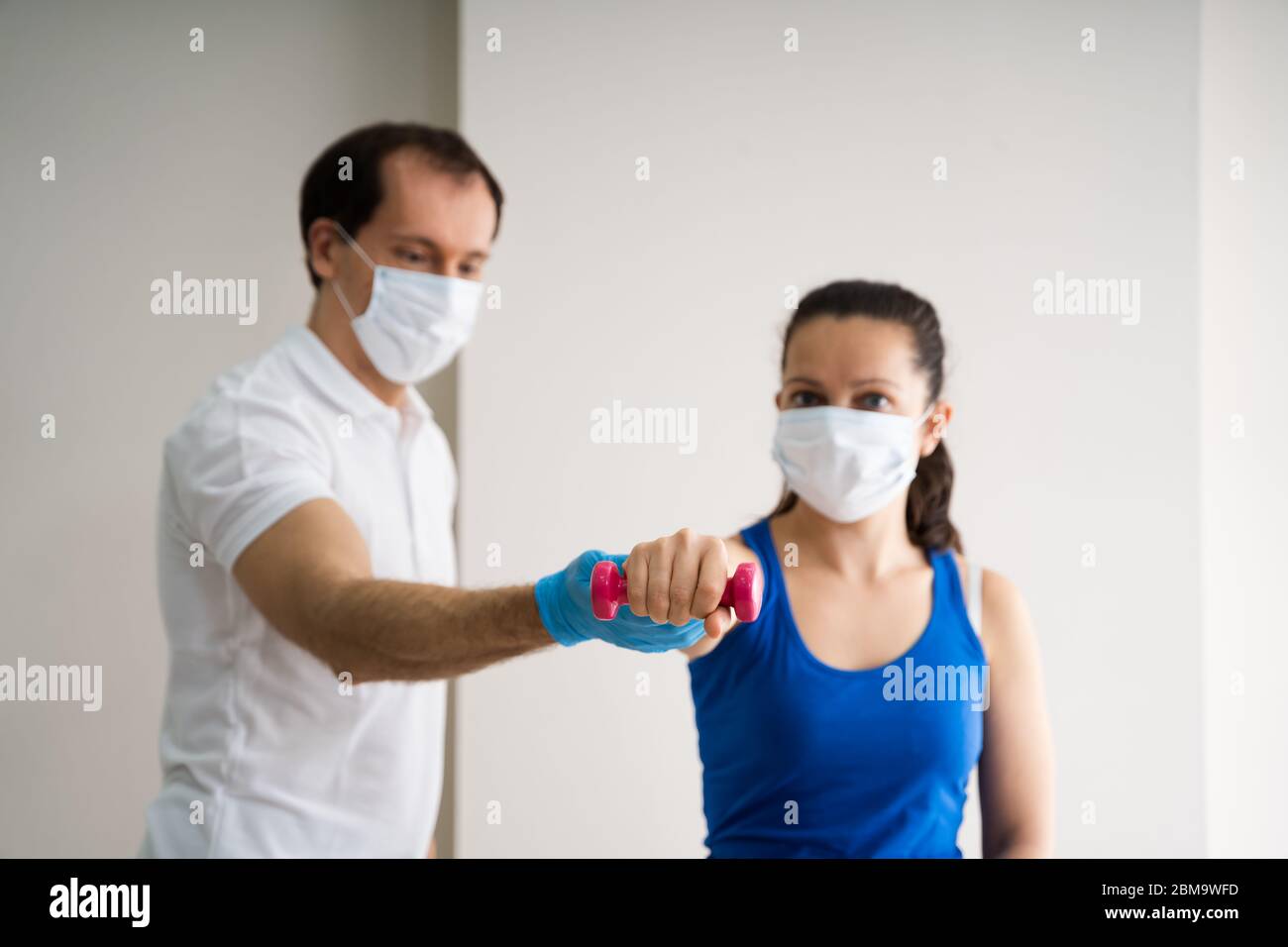 Physio Therapy Physical Trainer In Face Mask Stock Photo - Alamy