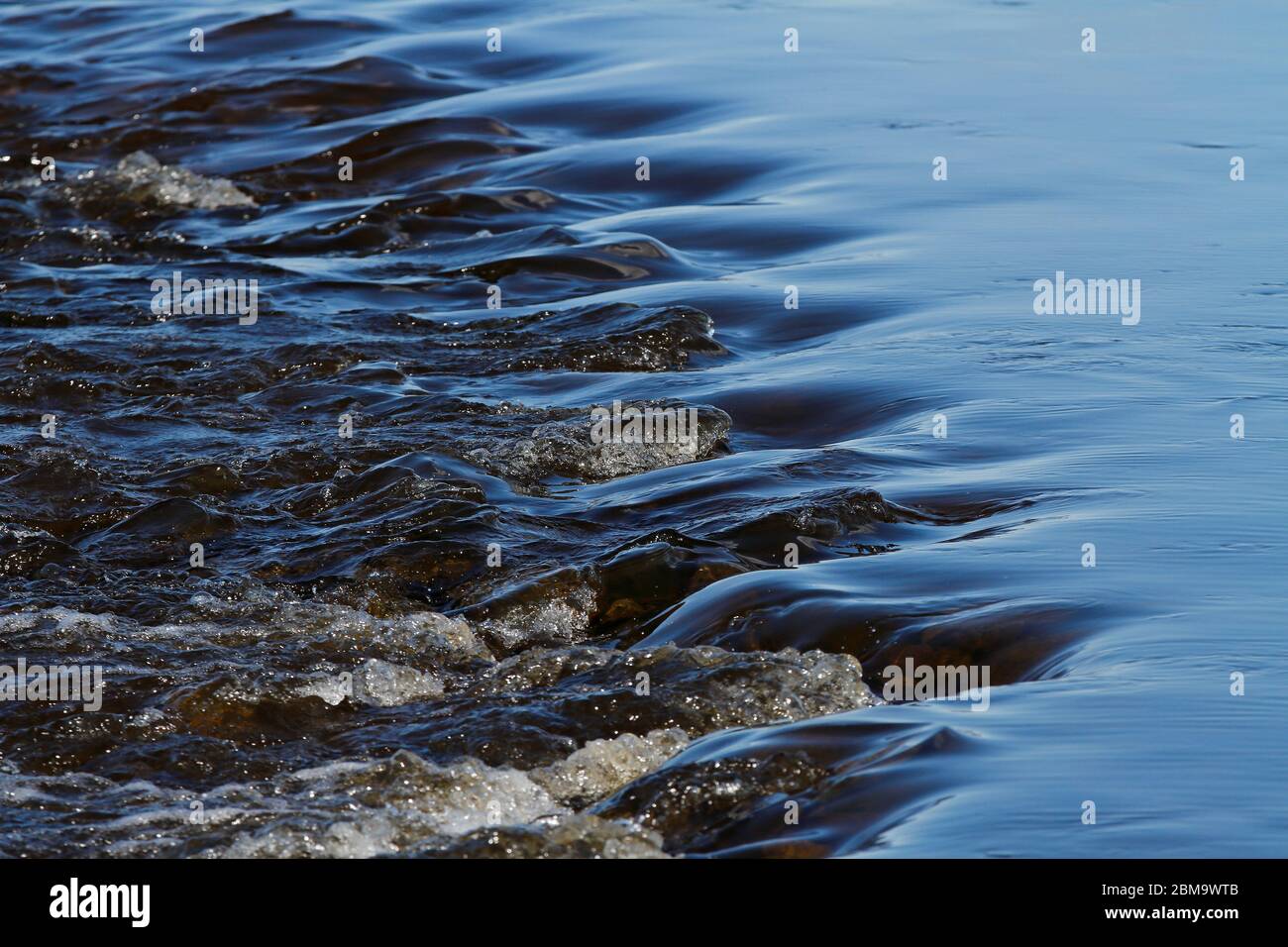 A line of rocks in hard flowing stream in Finnish rapids Stock Photo ...