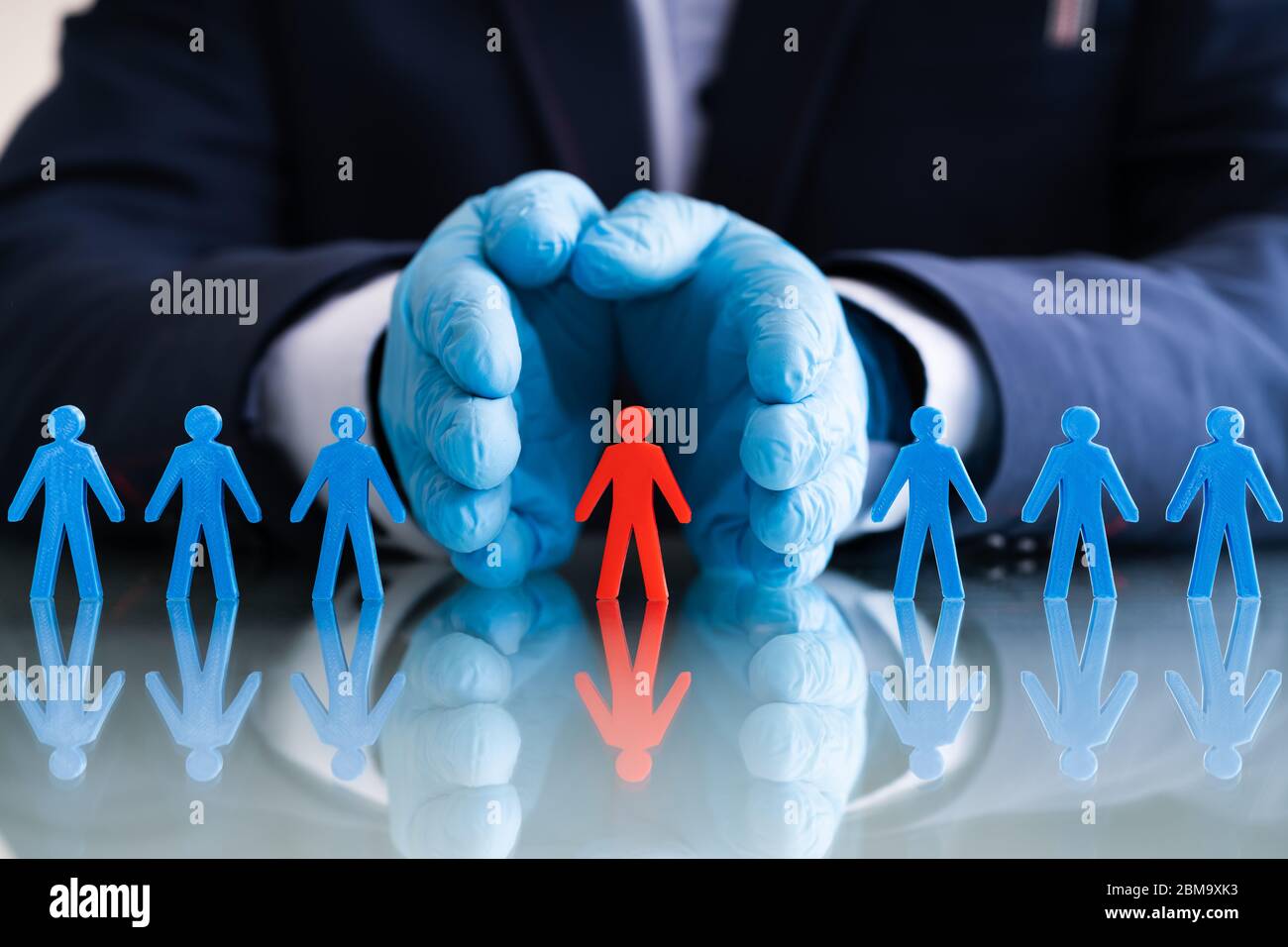 Hand In Gloves Selecting Red Person Figure Stock Photo - Alamy