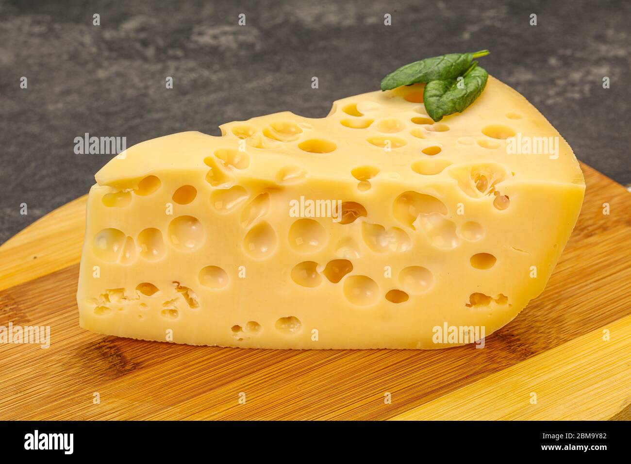 Maasdam cheese - dairy yellow triangle with holes Stock Photo - Alamy