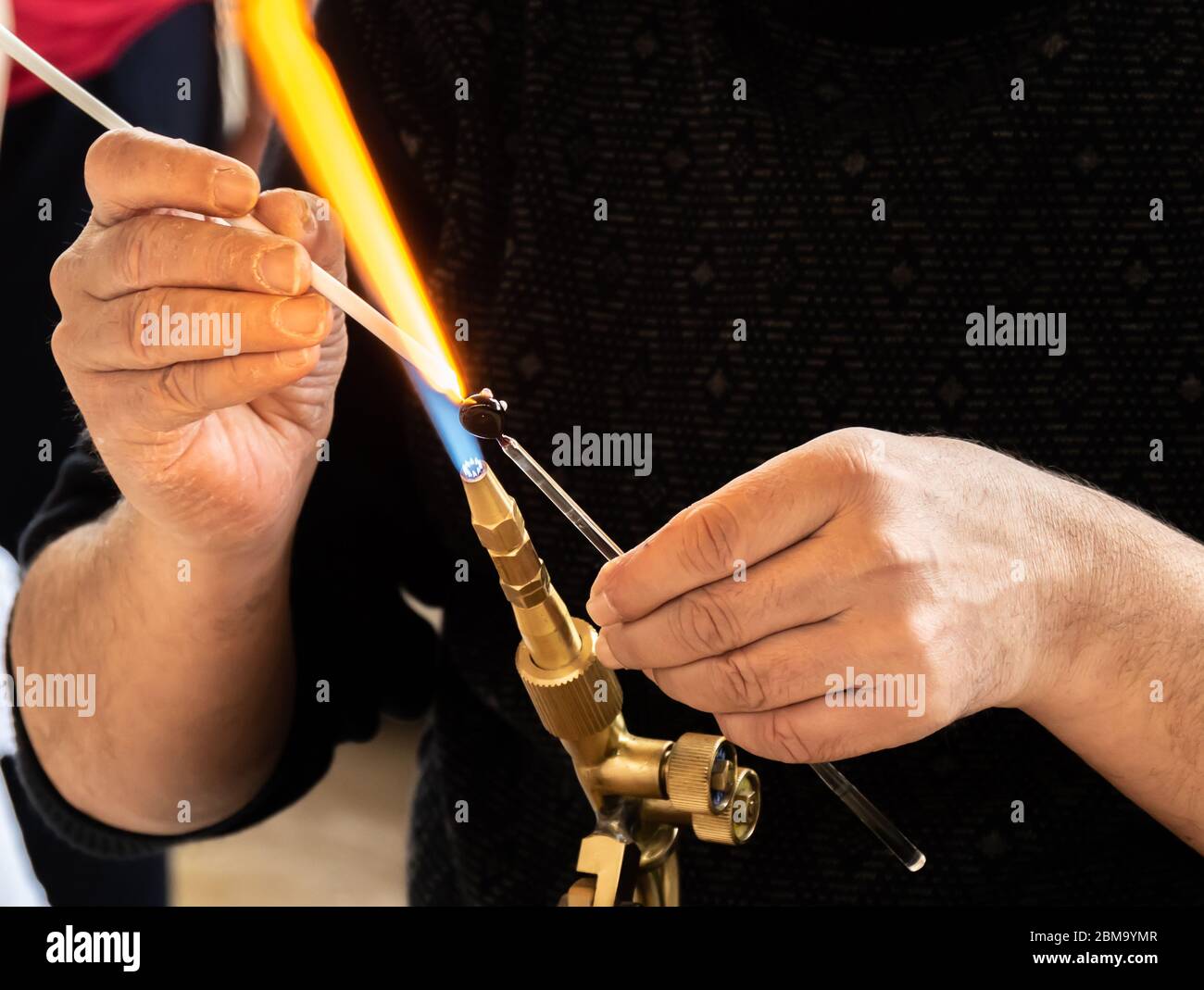 Hands of the handicrafts man making a glass subject of crafts. Glass ...