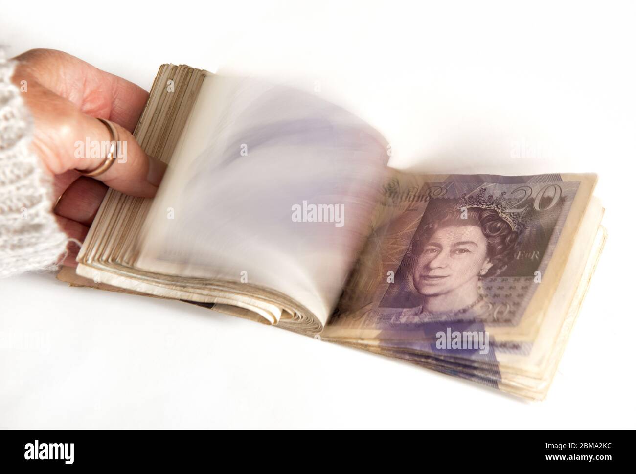 Woman counting twenty pound notes on a white background Stock Photo - Alamy