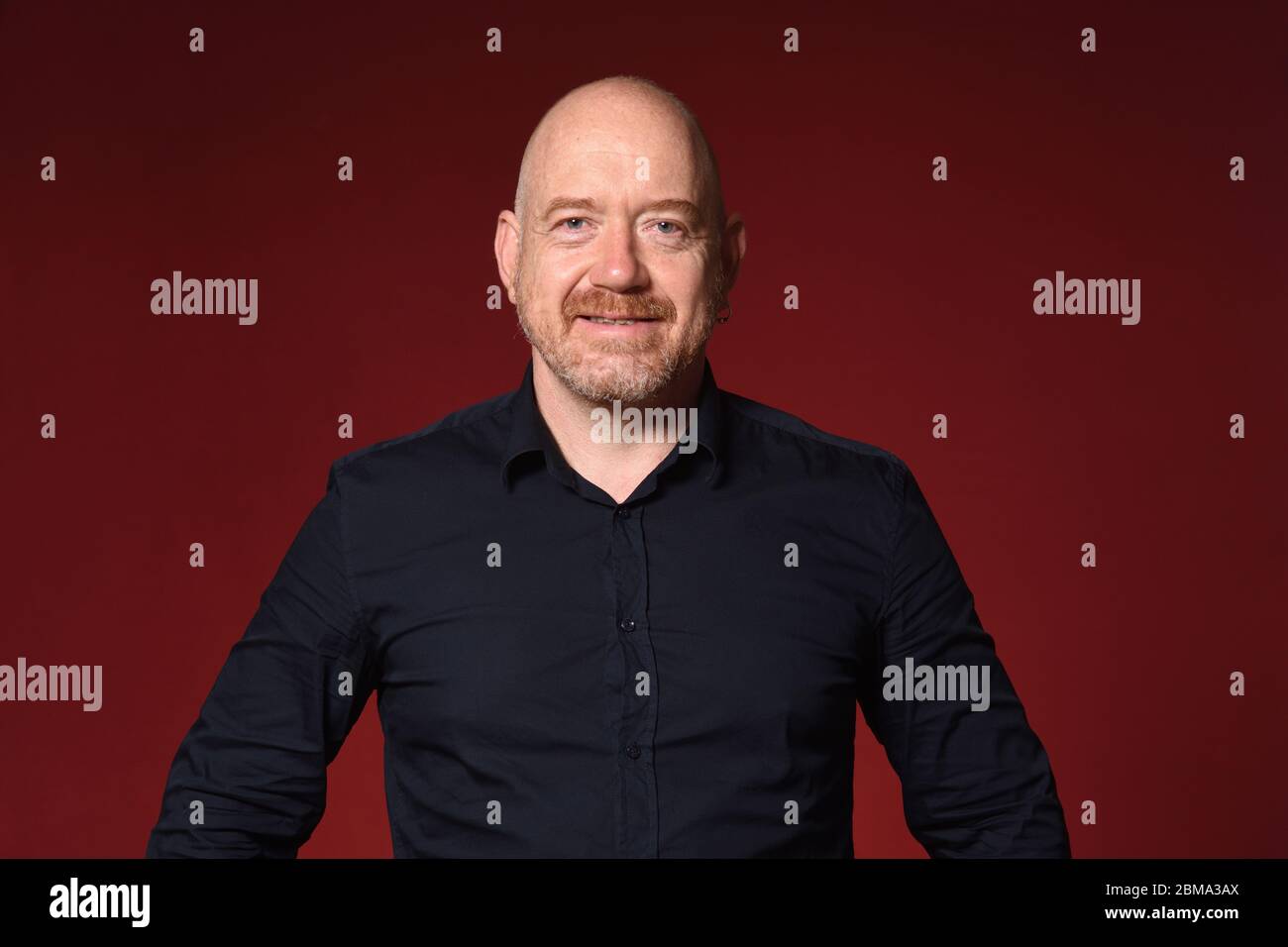 bald man smiling on red background Stock Photo - Alamy