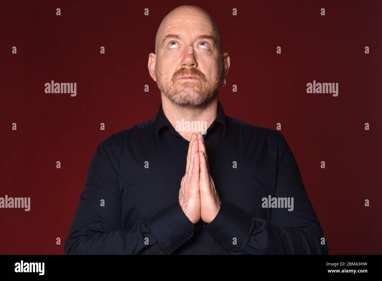 man praying on red background, look up Stock Photo - Alamy