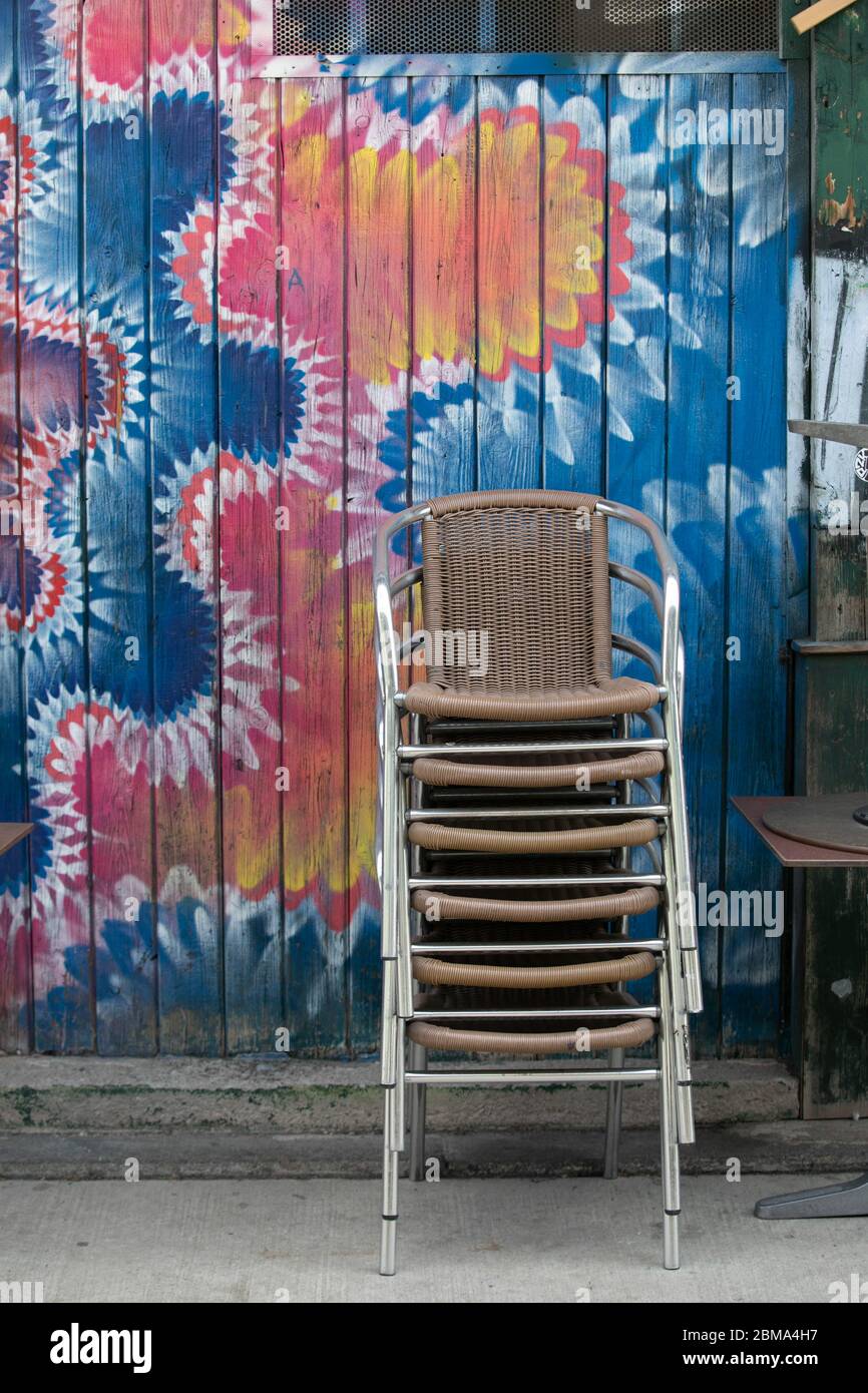 stacked chairs in front of a closed market stall Stock Photo - Alamy